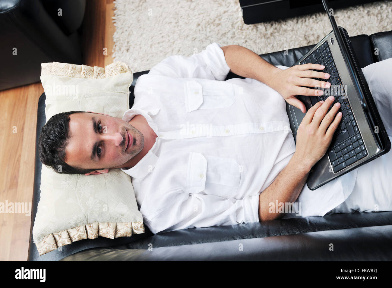 Portrait of a relaxed young guy using laptop at home Stock Photo - Alamy