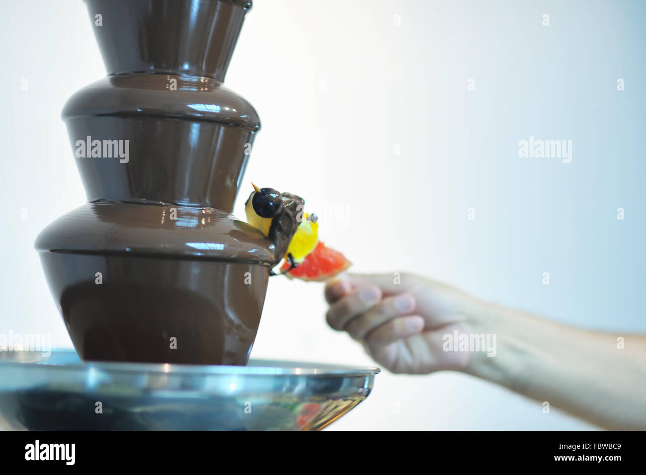 liquid chocolate fountain and fresh fruits on stick Stock Photo - Alamy