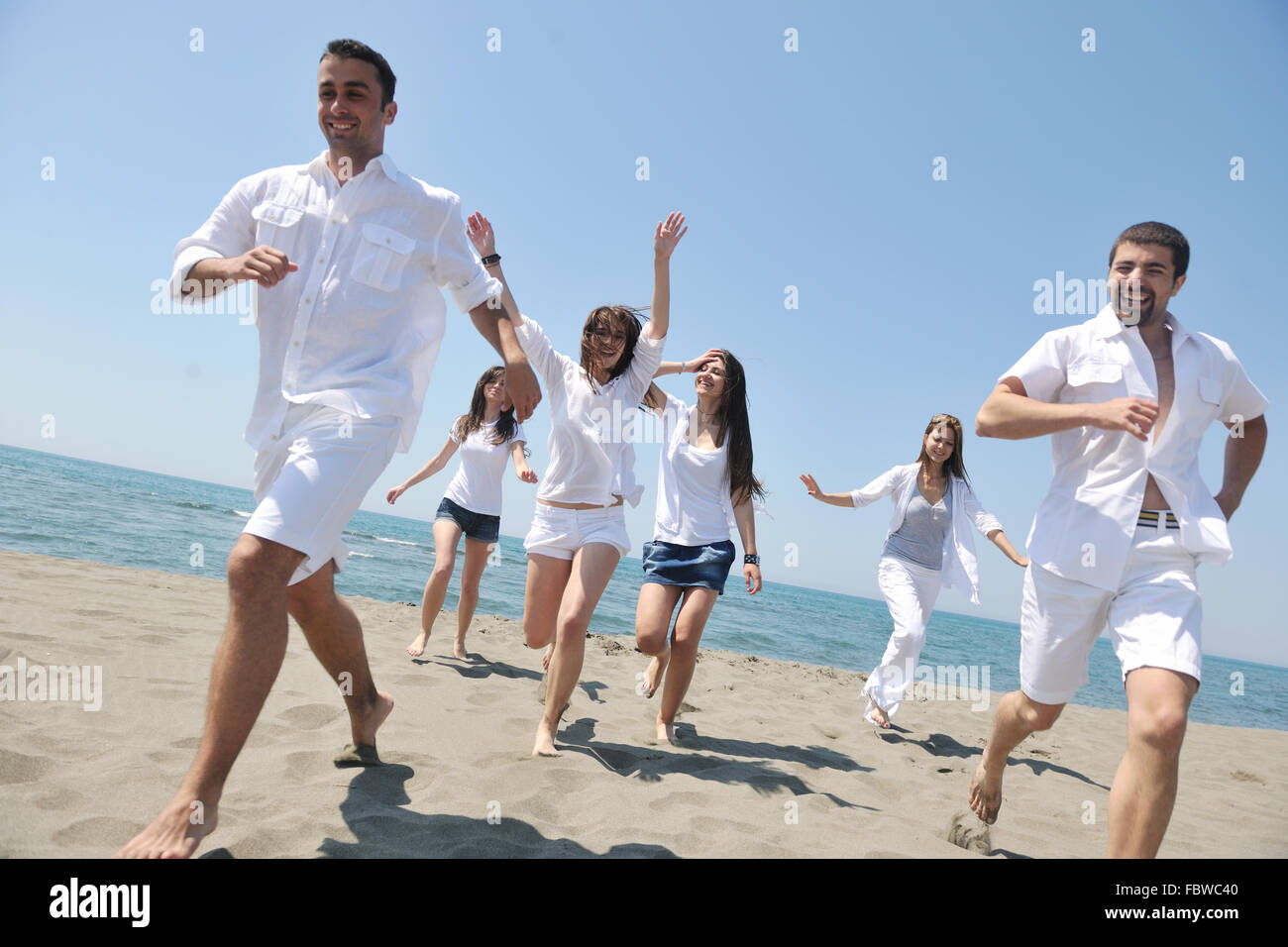 happy people group have fun and running on beach Stock Photo - Alamy