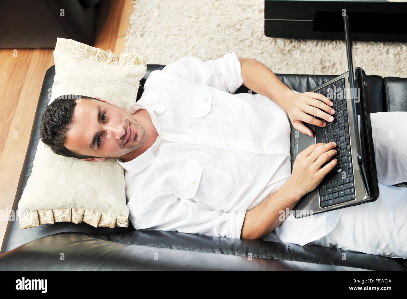 Portrait of a relaxed young guy using laptop at home Stock Photo - Alamy