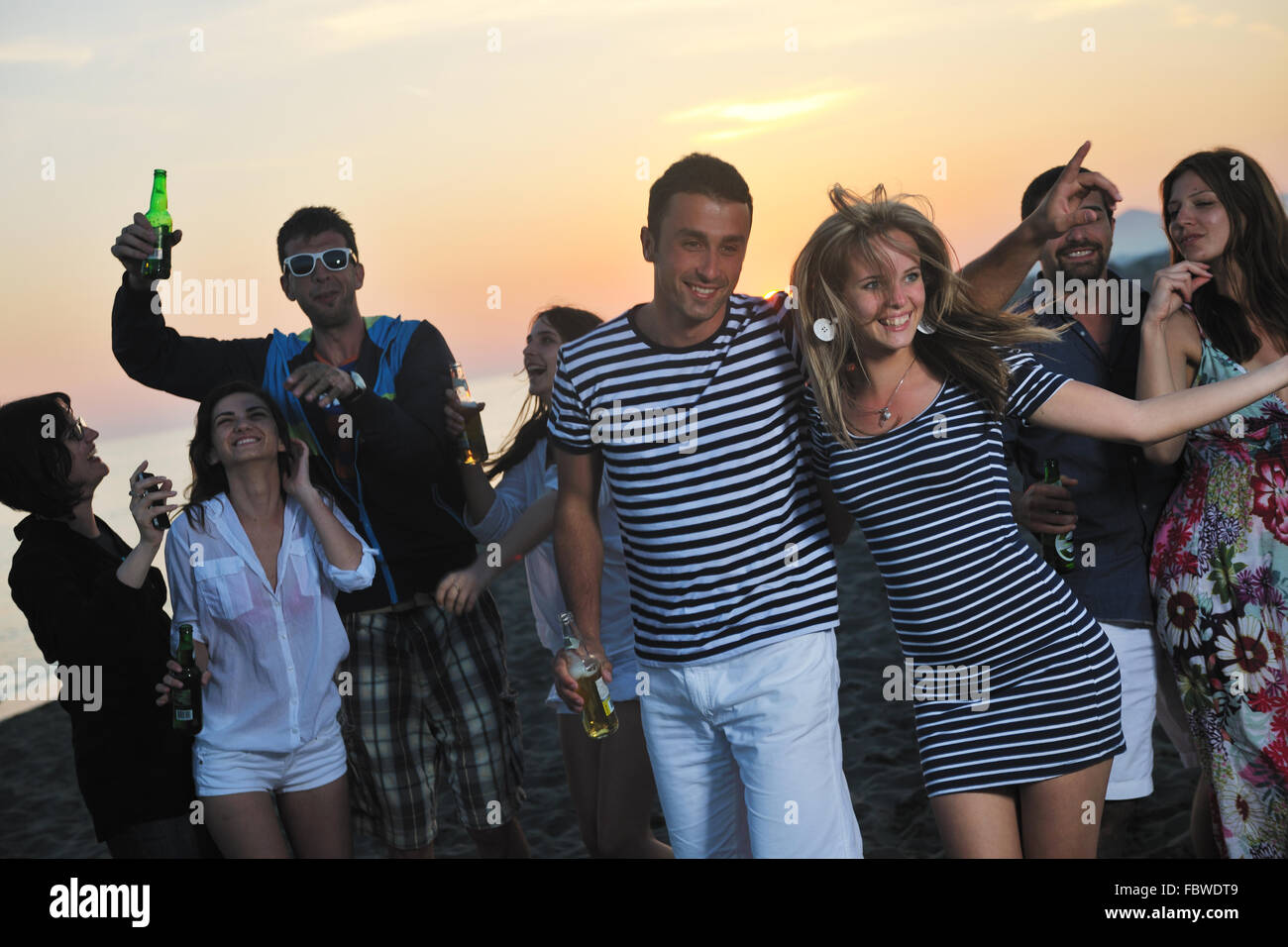 Group of young people enjoy summer party at the beach Stock Photo - Alamy