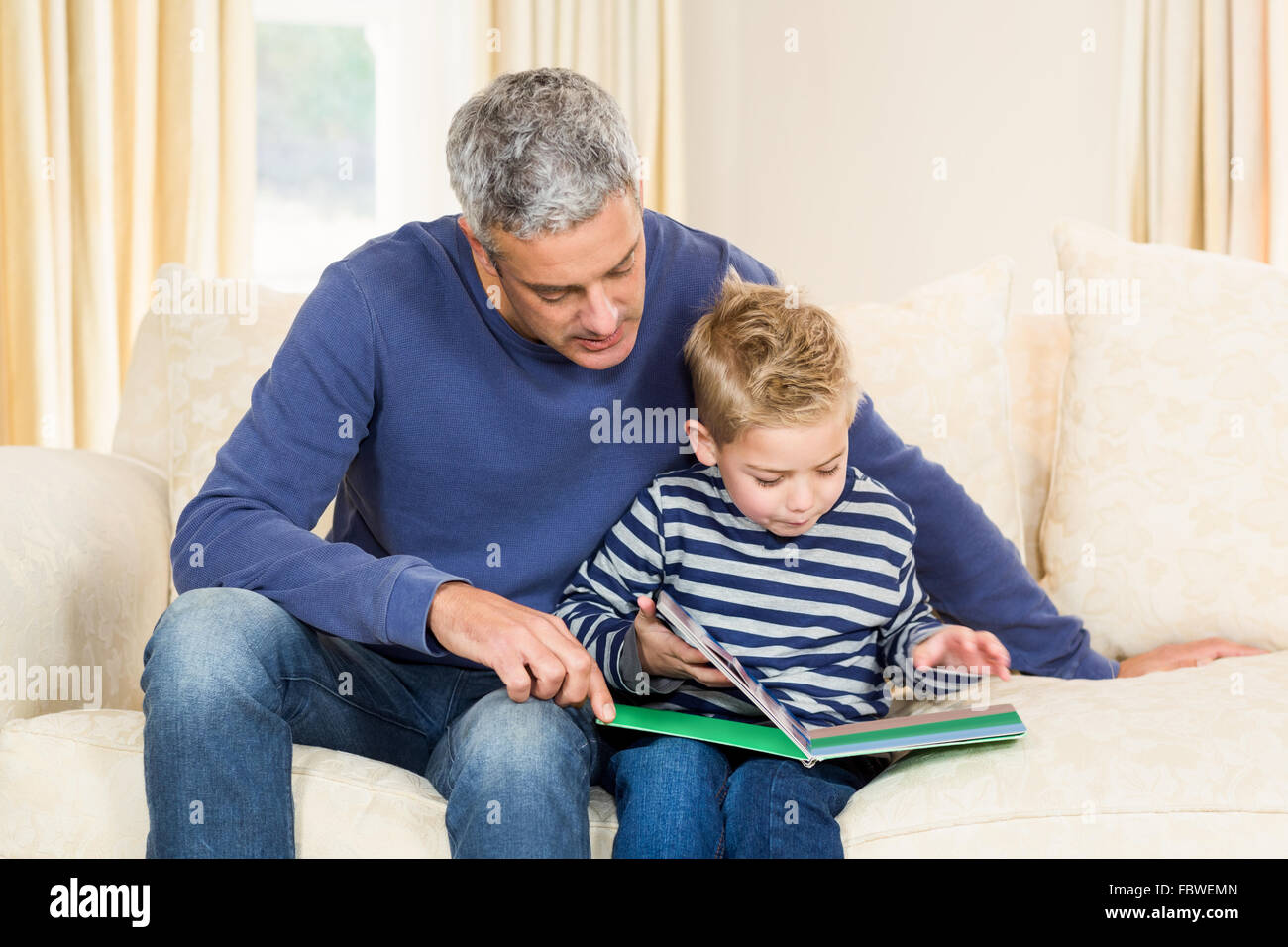 Father and son reading book Stock Photo - Alamy