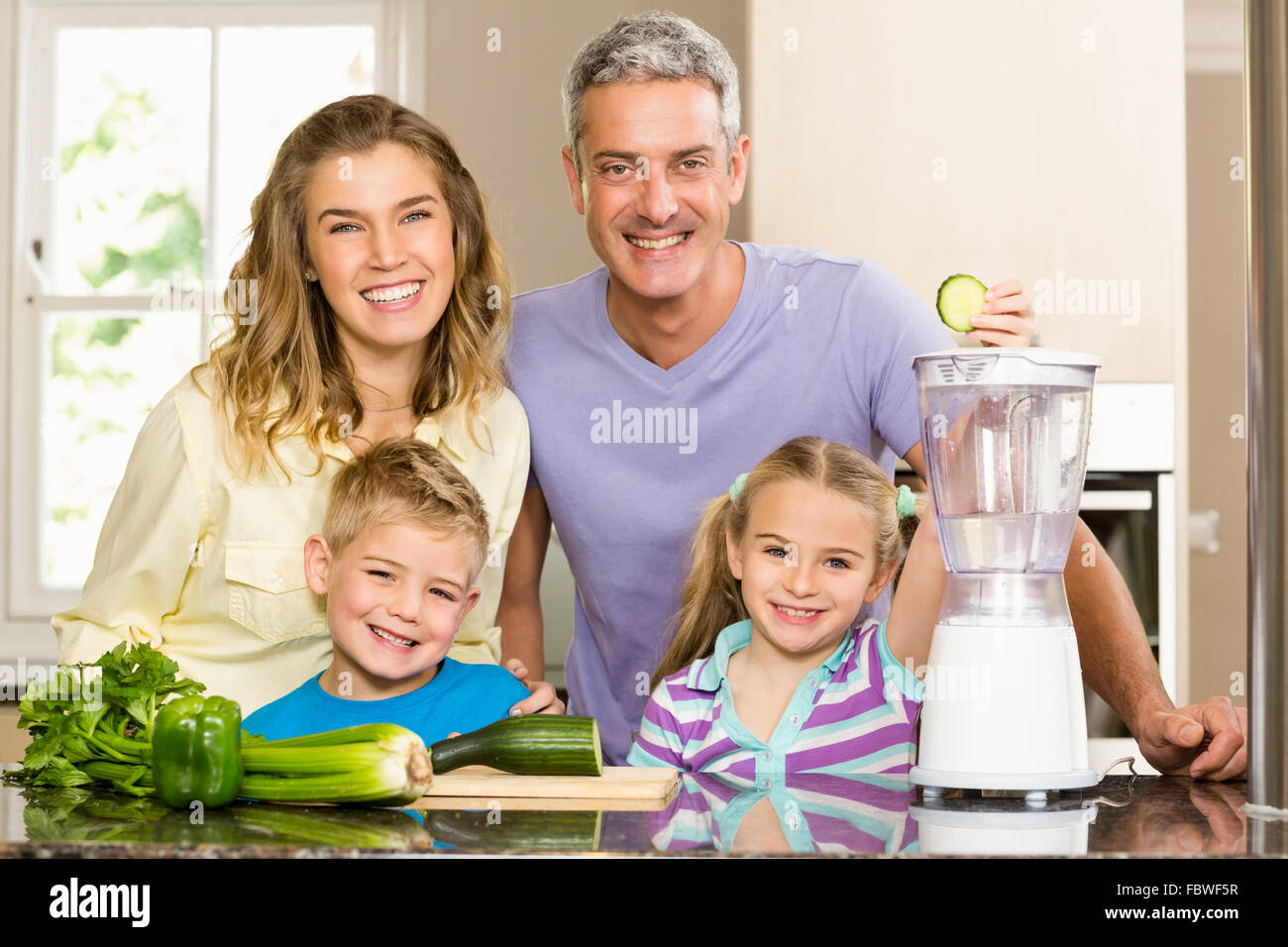 Happy family preparing healthy smoothie Stock Photo - Alamy