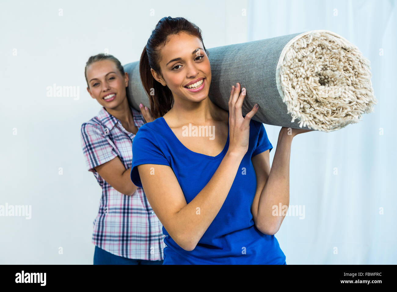 Friends holding a carpet Stock Photo - Alamy