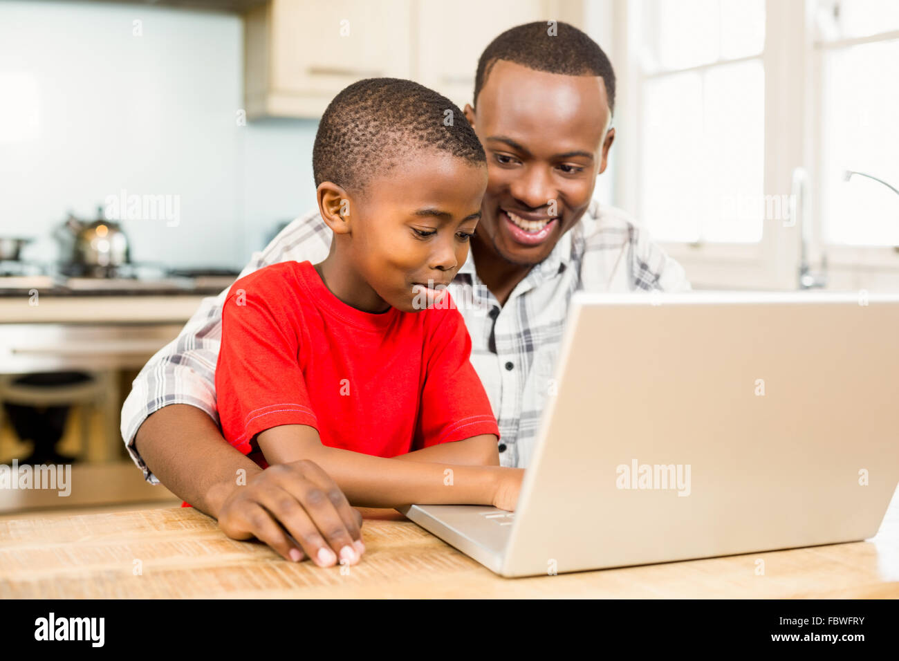Father and son using laptop together Stock Photo - Alamy