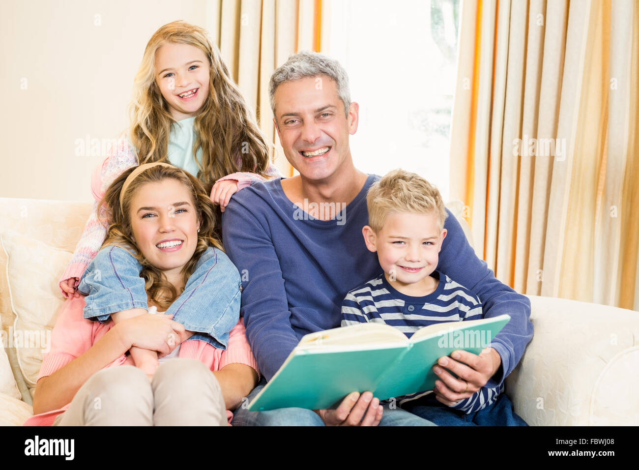 Happy parents reading to their kids Stock Photo - Alamy