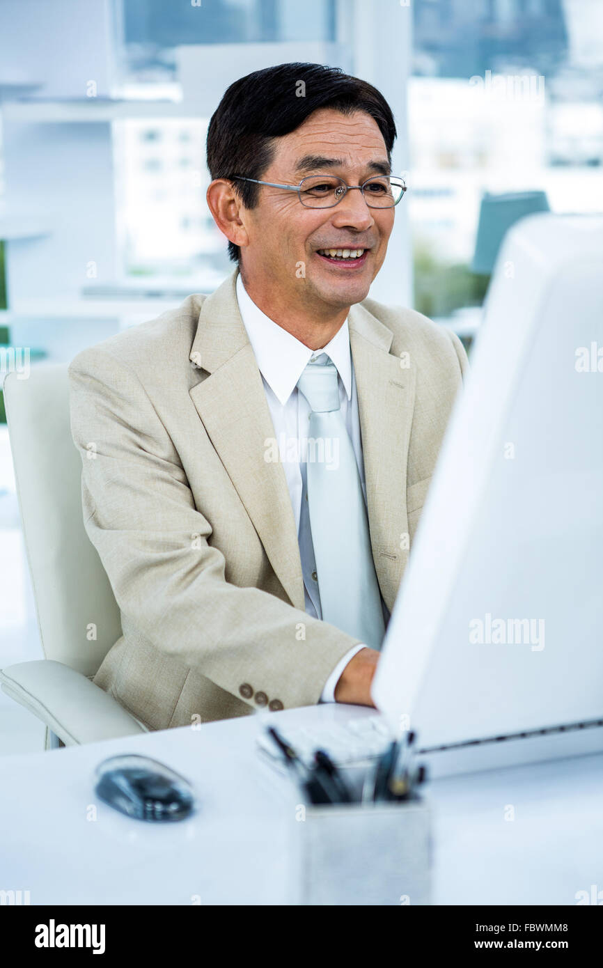 Smiling businessman using his computer Stock Photo - Alamy