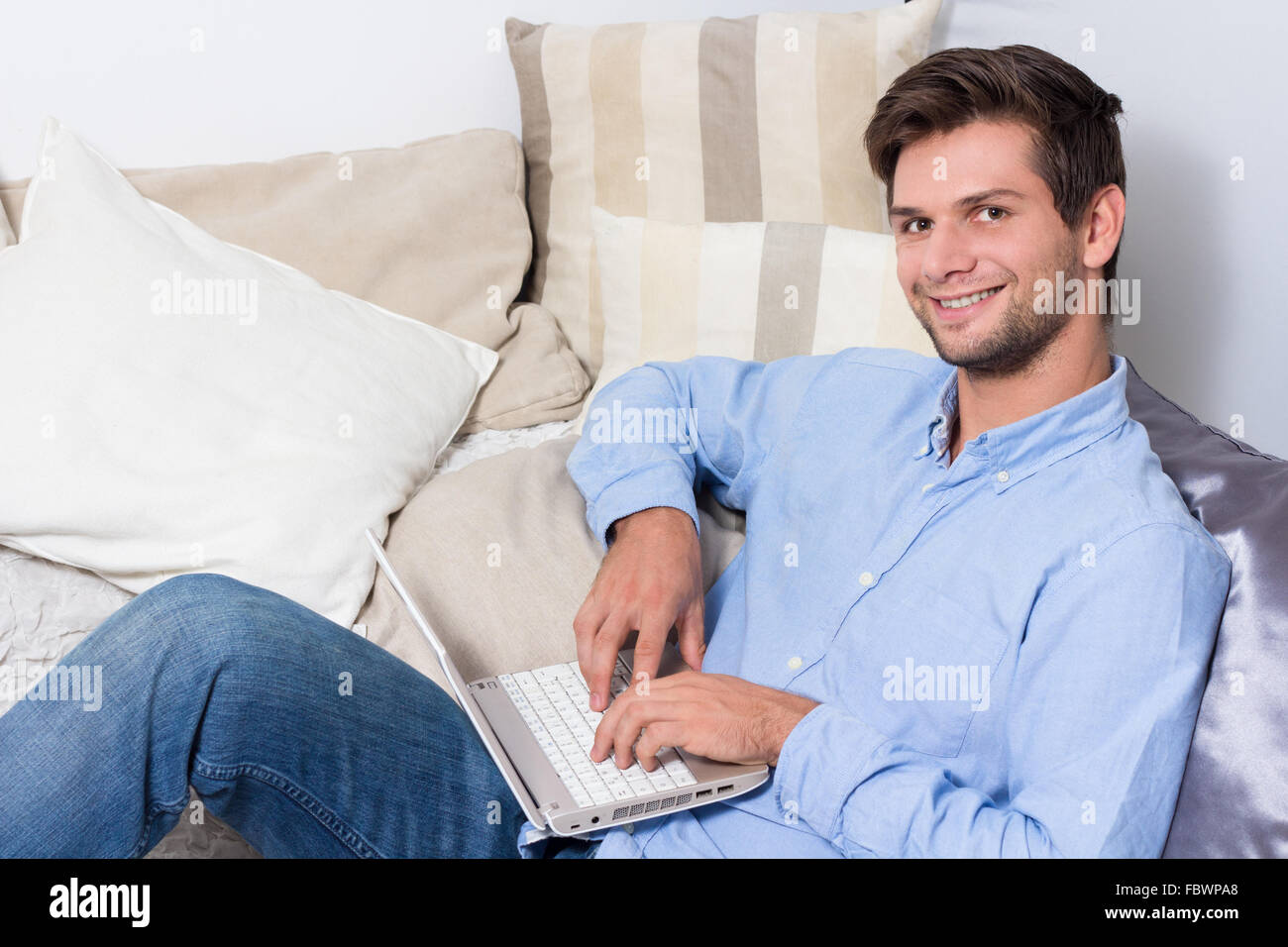 Man on couch with laptop hi-res stock photography and images - Alamy