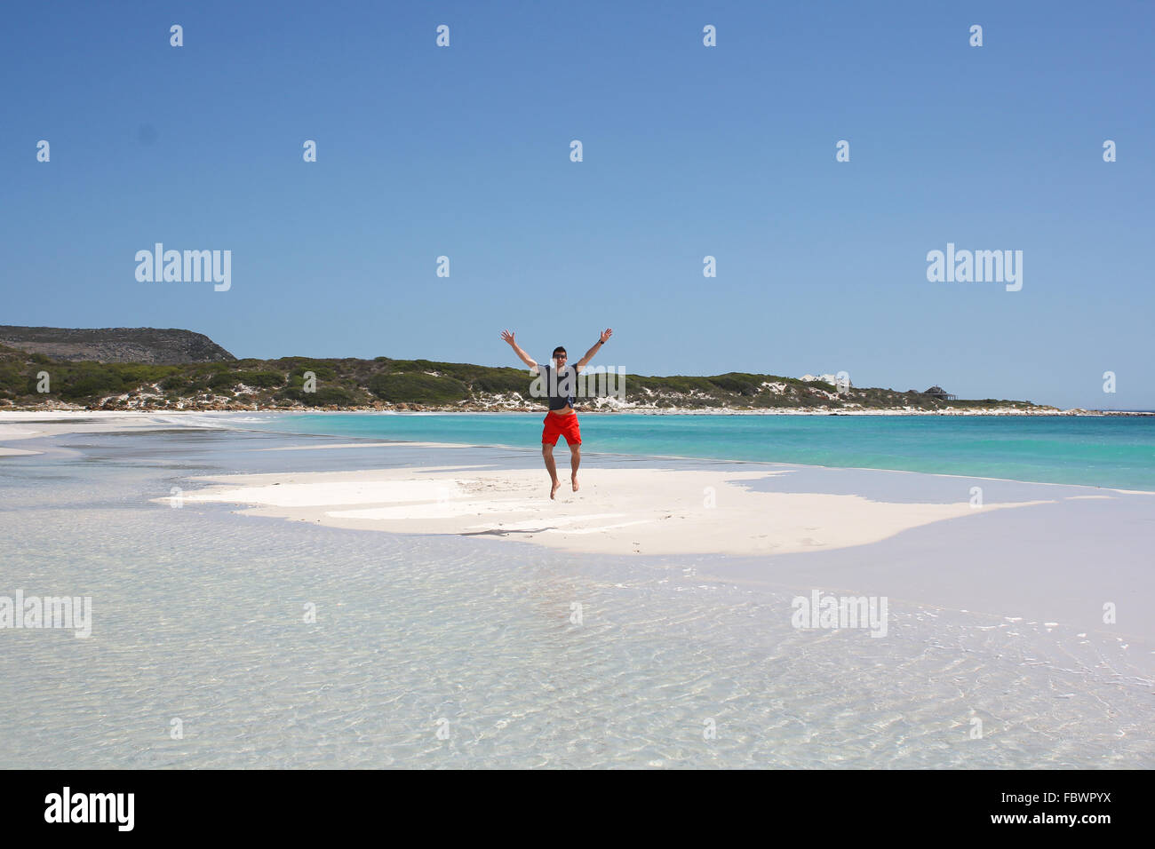 Man jumpin on small island Stock Photo - Alamy
