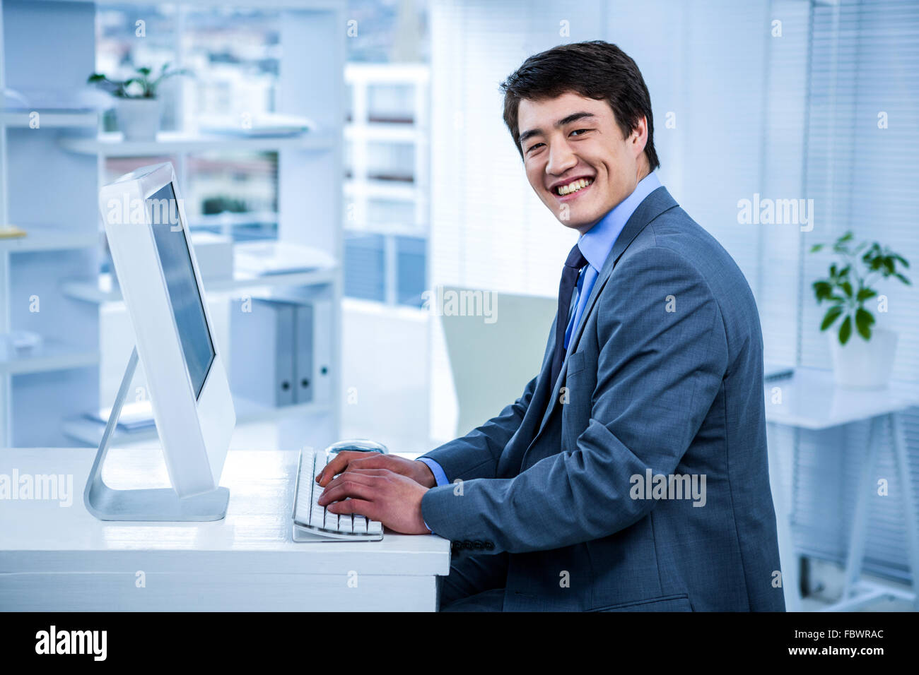 Smiling businessman using his computer Stock Photo - Alamy