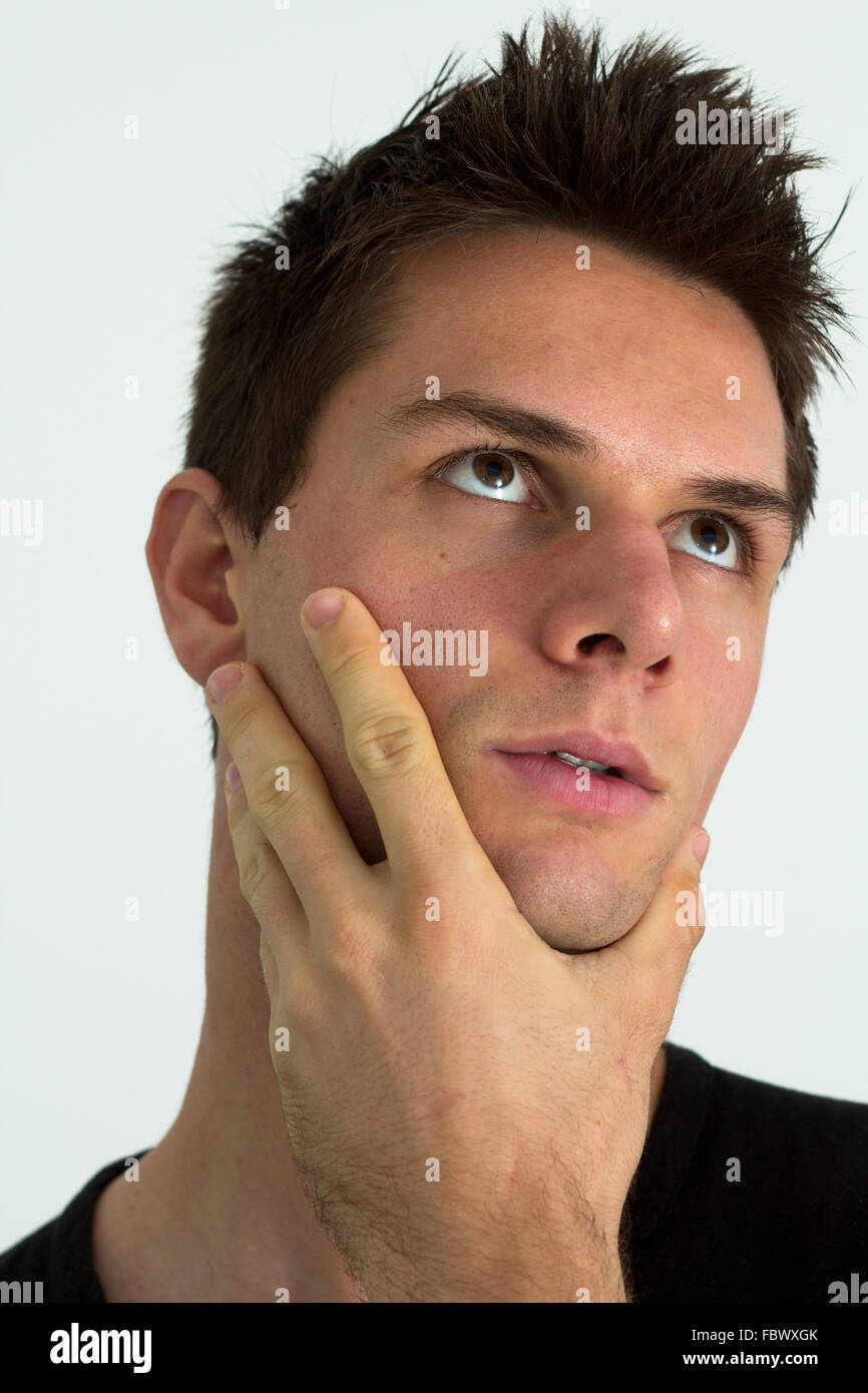 Man thinking with hand on face Stock Photo - Alamy