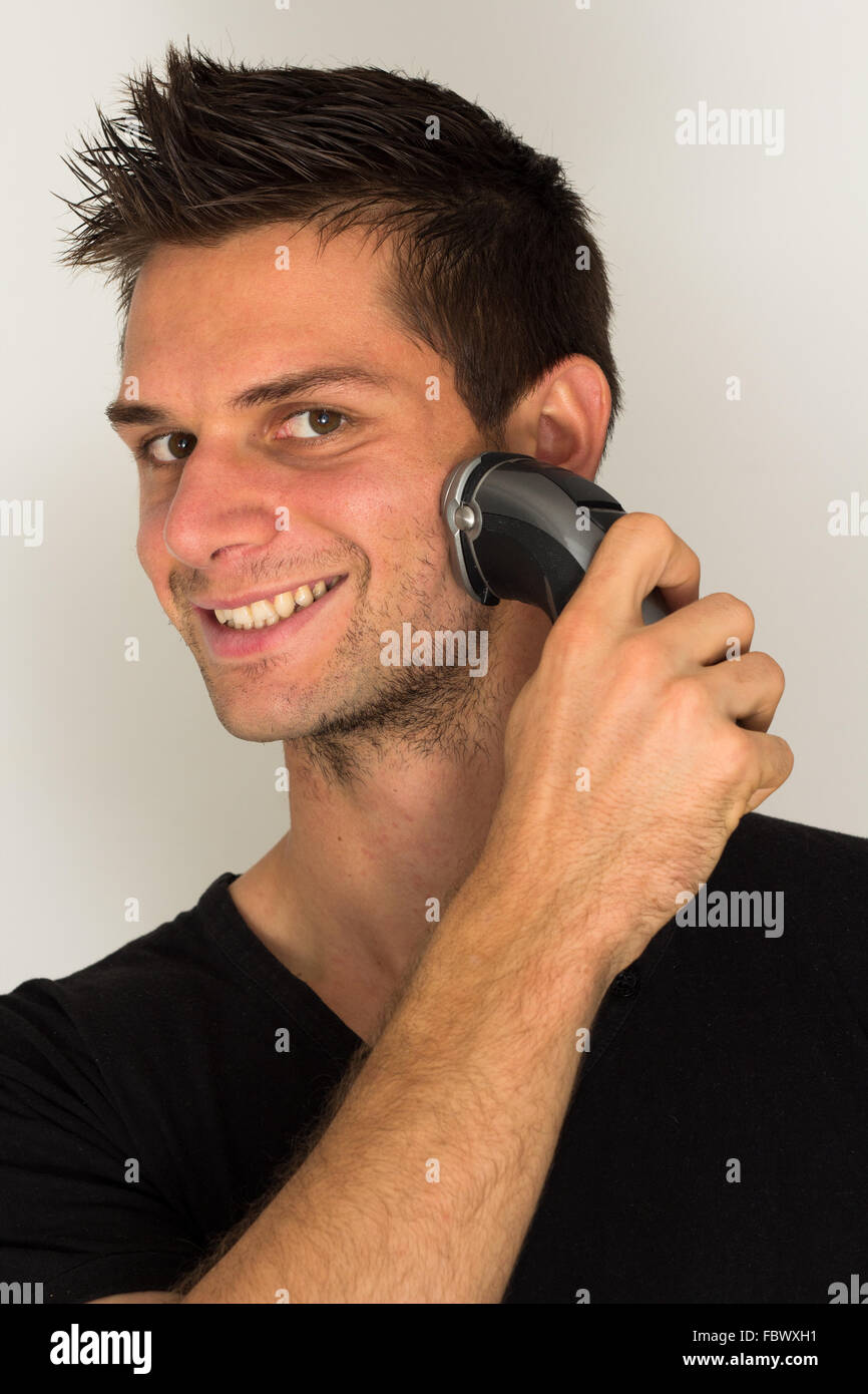Man shaving face with electric razor Stock Photo - Alamy