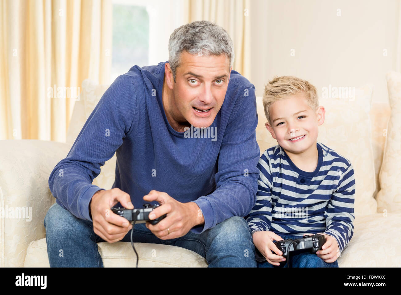 Father and son playing video games Stock Photo - Alamy