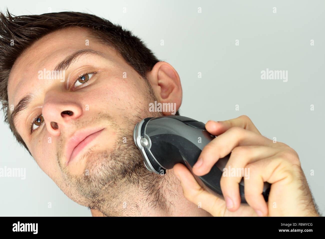 Man shaving face with electric razor Stock Photo - Alamy