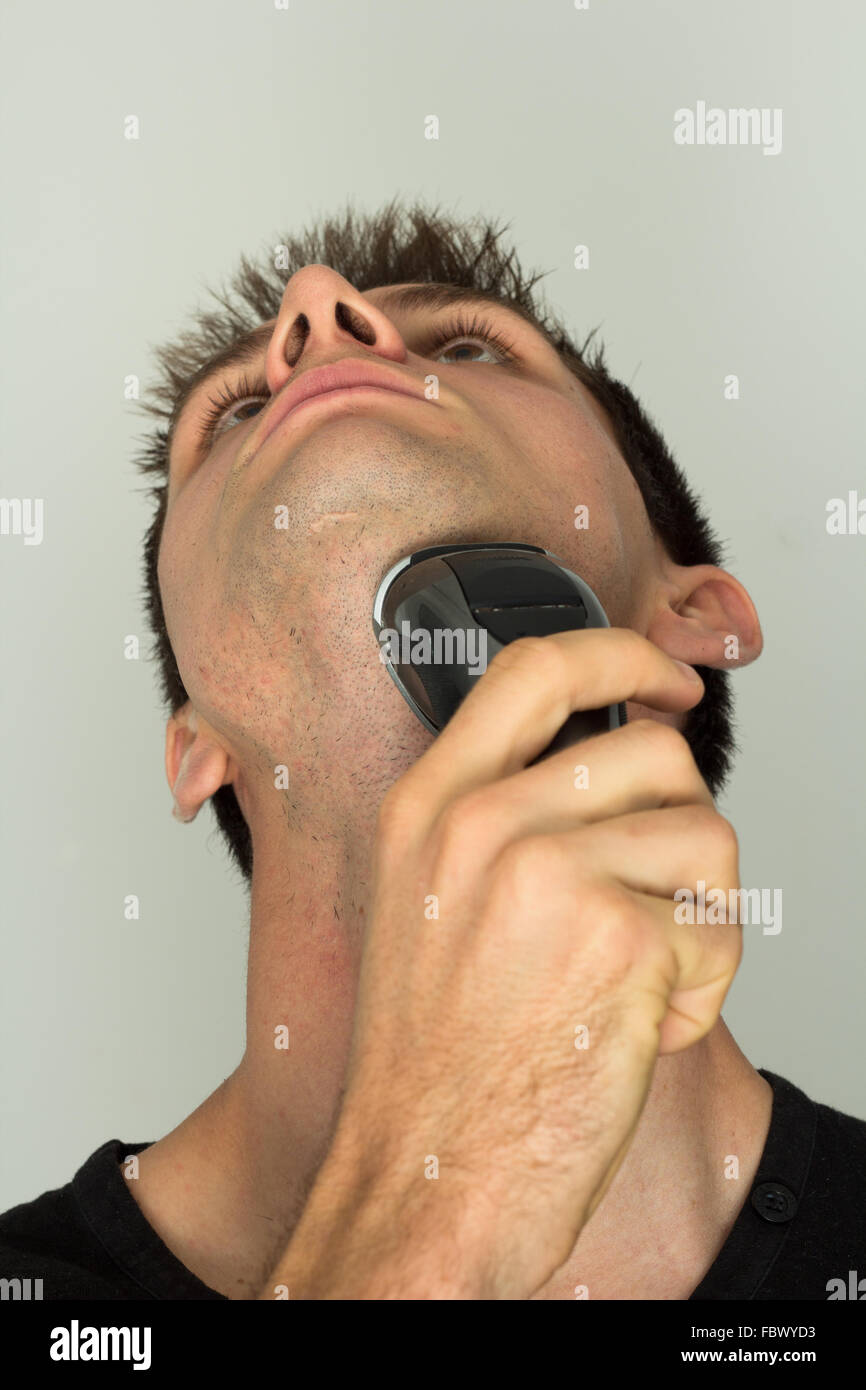 Man shaving face with electric razor Stock Photo - Alamy