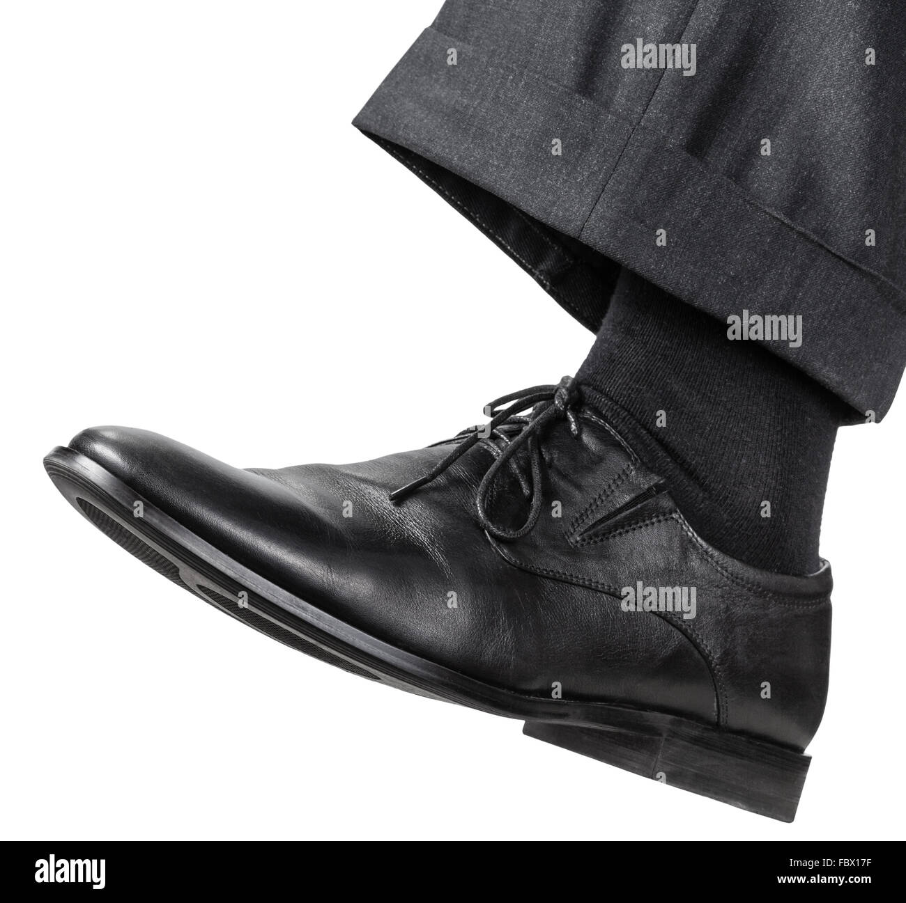 side view of male left foot in black shoe takes a step isolated on ...