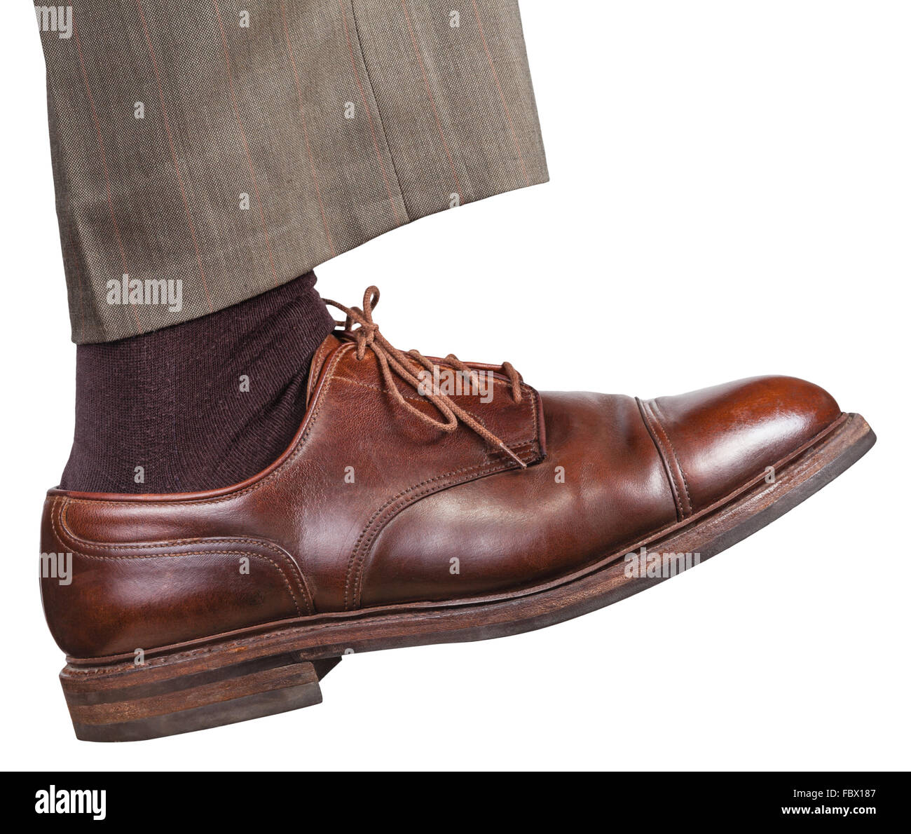 side view of male right leg in brown shoe takes a step isolated on ...
