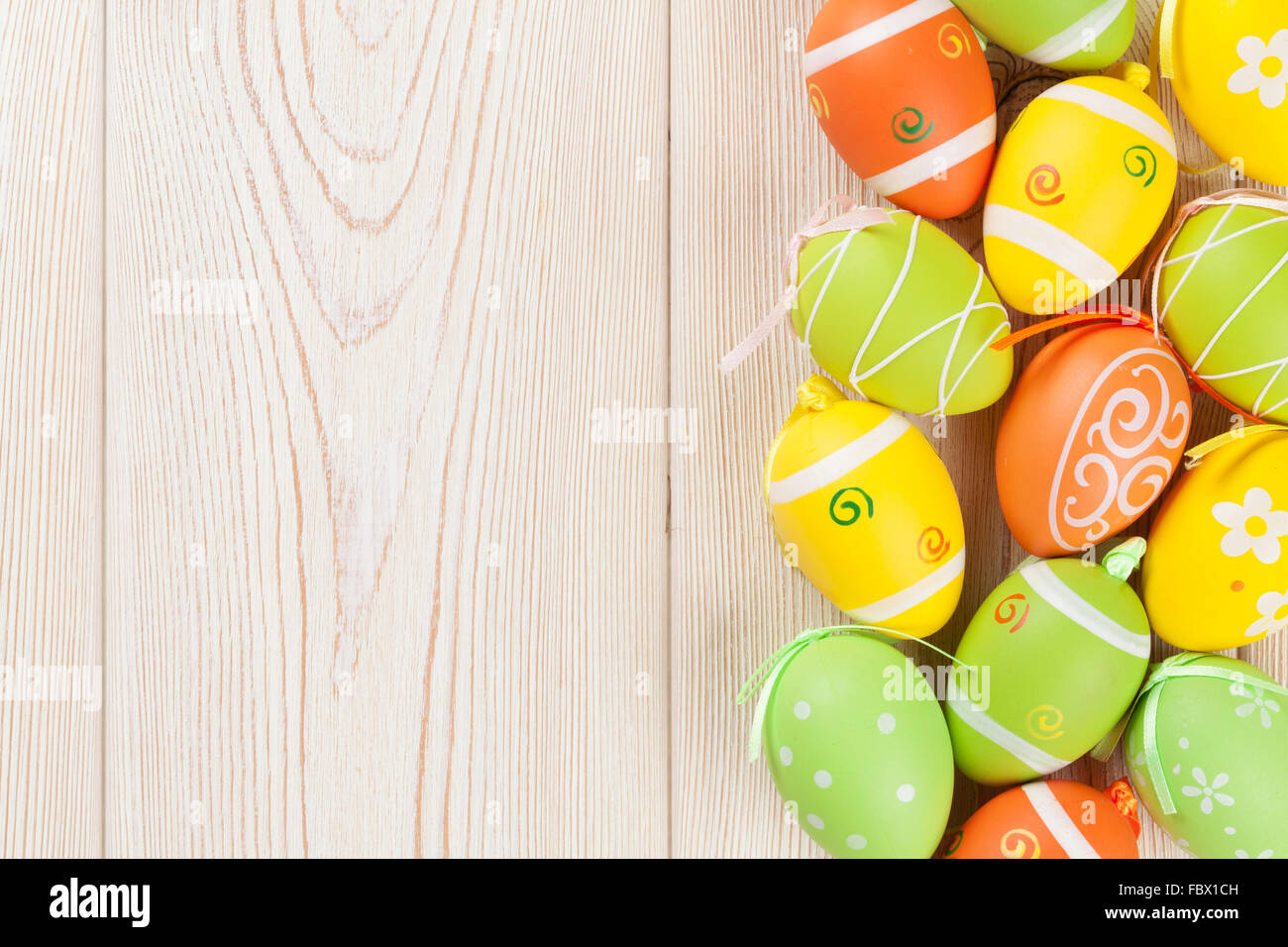 Easter background with colorful eggs over wooden table. Top view with ...