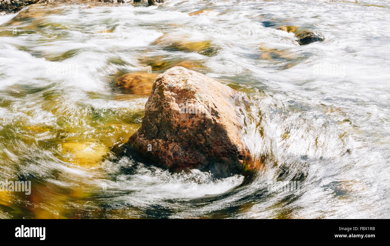 The mountain river in Norway. The flow of clear pure water surrounds ...