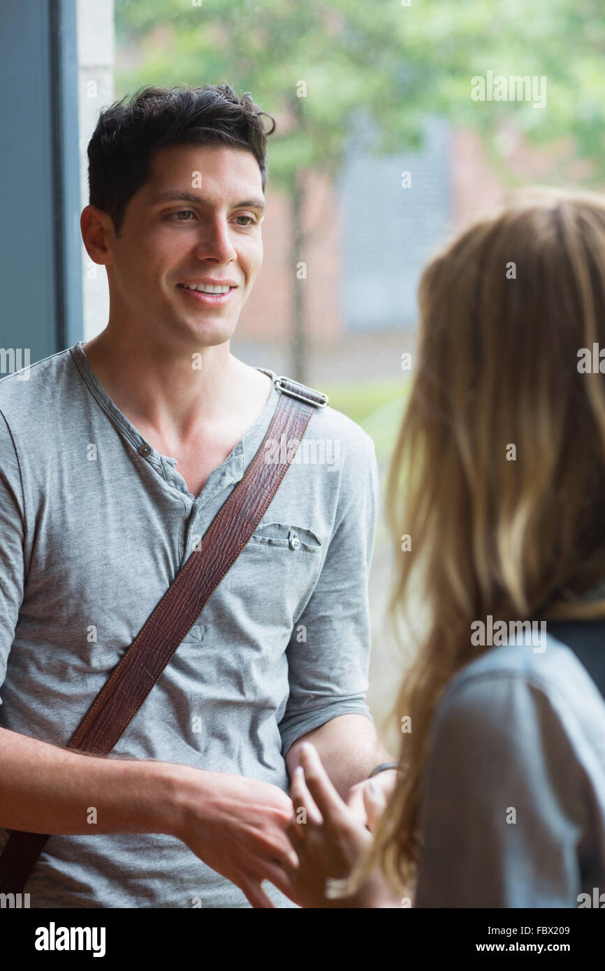 Smiling male student talking to a friend Stock Photo - Alamy