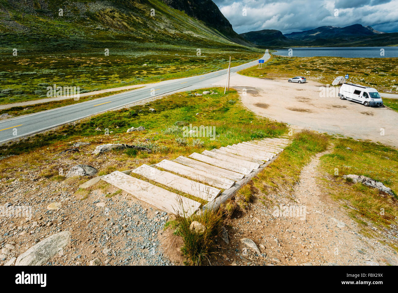 Asphalt country road in the mountains in Norway. Cars are on the side ...