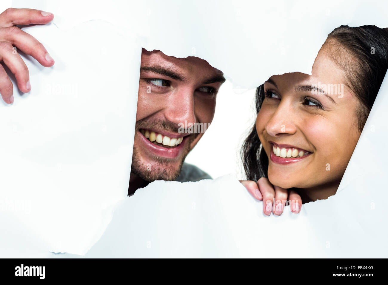 Couple peeking through torn paper Stock Photo - Alamy