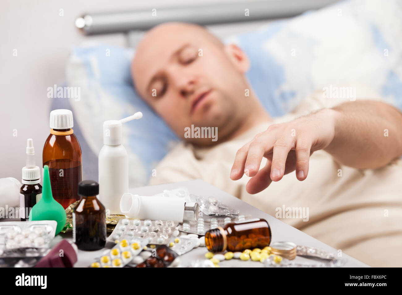 Unwell man patient lying down bed Stock Photo - Alamy