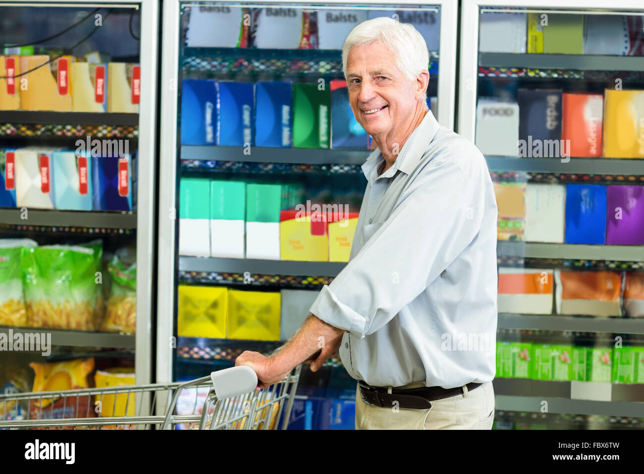 Smiling senior man pushing cart Stock Photo - Alamy