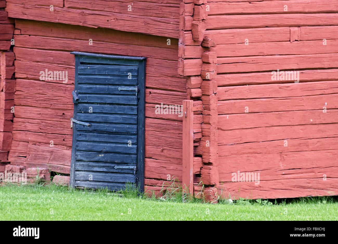 Red wooden log with blue door Stock Photo - Alamy