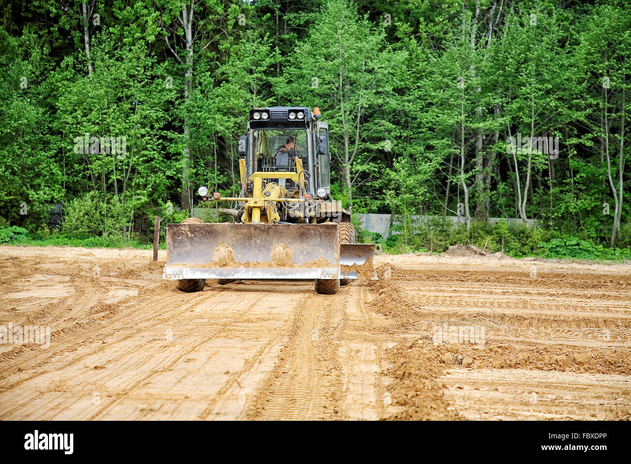 The grader clears away a ground Stock Photo - Alamy