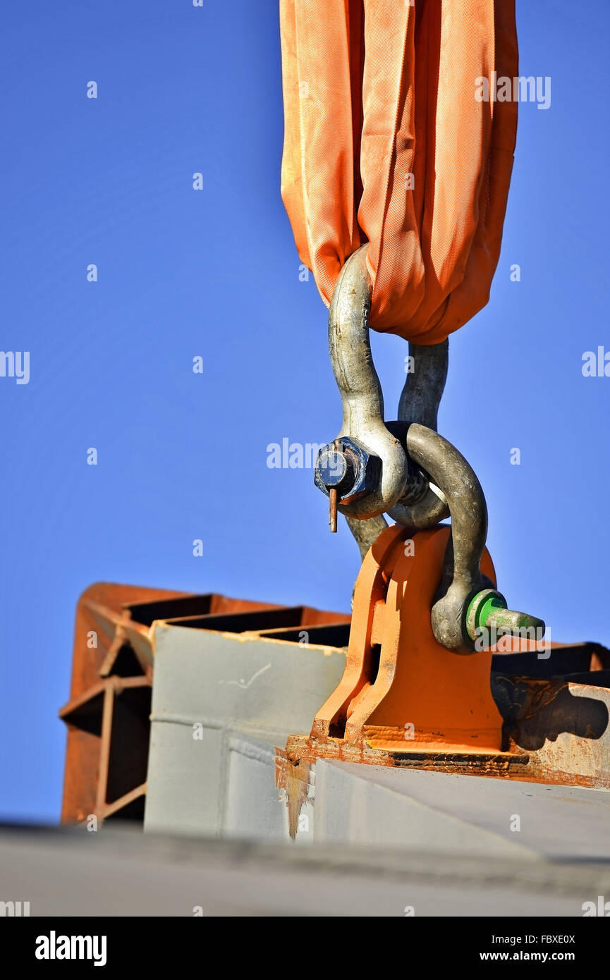 Heavy duty chain hooked up on a construction crane lifting concrete a ...