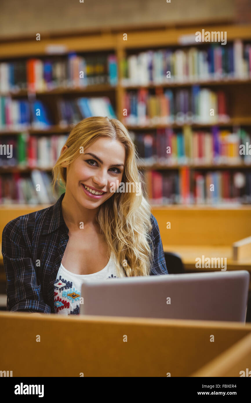 Smiling student working while using her laptop Stock Photo - Alamy