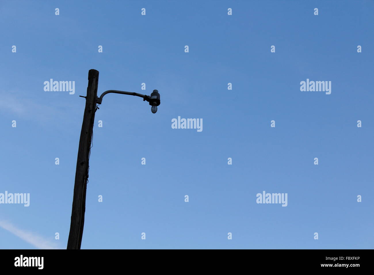 Rustic light pole against blue sky Stock Photo - Alamy