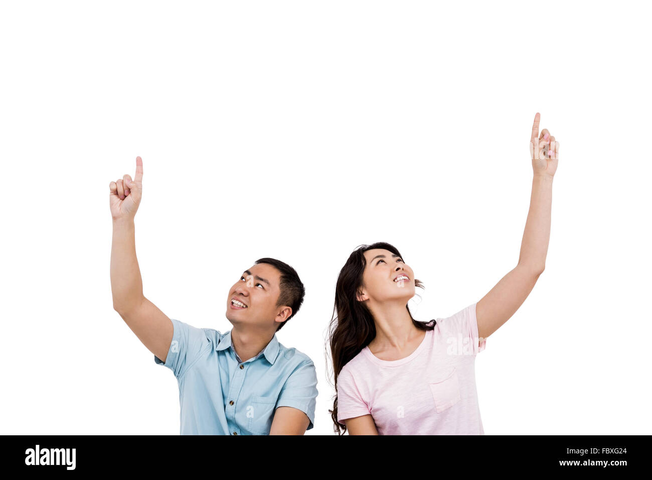 Happy young couple pointing up Stock Photo - Alamy