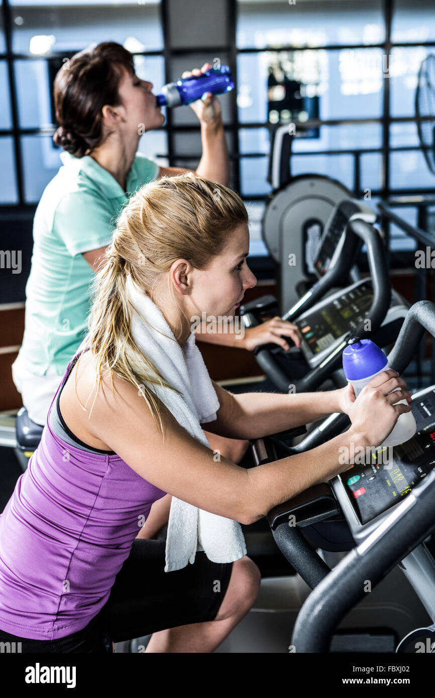 Fit women doing exercise bike Stock Photo - Alamy