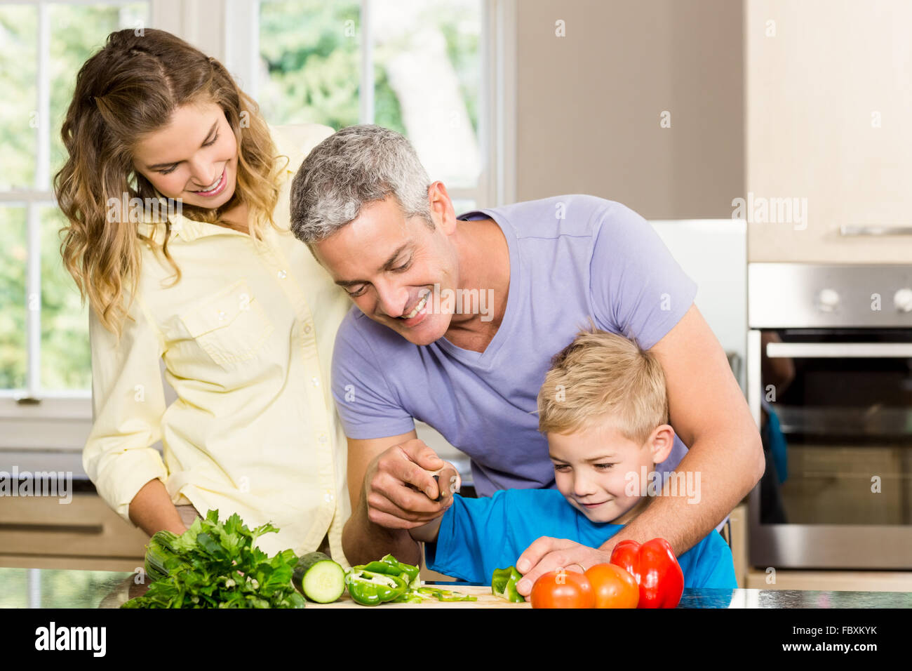 Happy family slicing vegetables Stock Photo - Alamy
