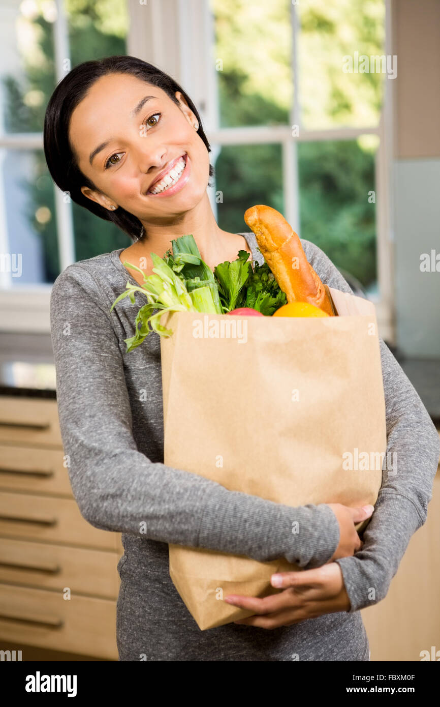 Smiling brunette holding grocery bag Stock Photo - Alamy Smiling brunette holding grocery bag Stock Photo - Alamy