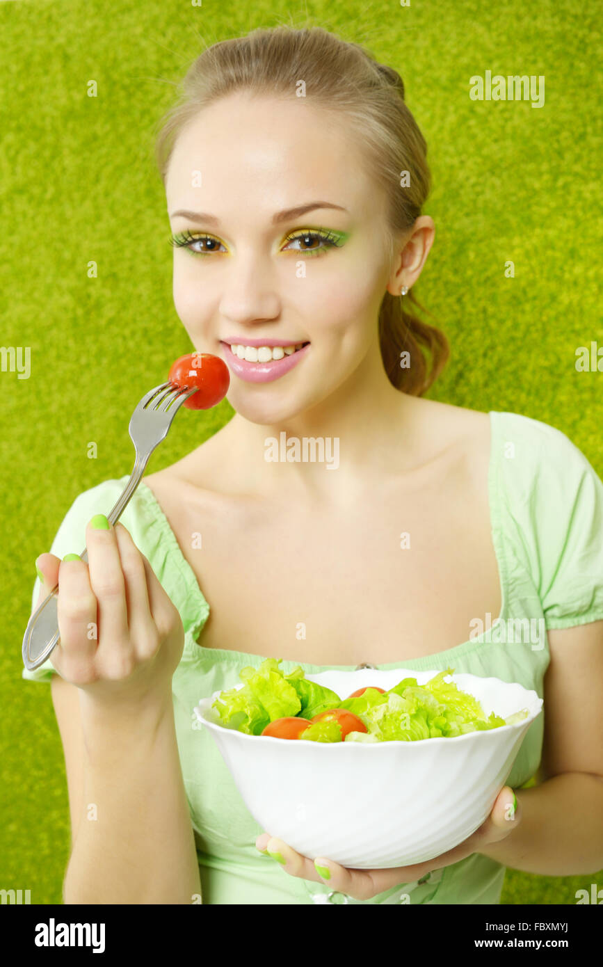 Smiling girl eating salad Stock Photo - Alamy
