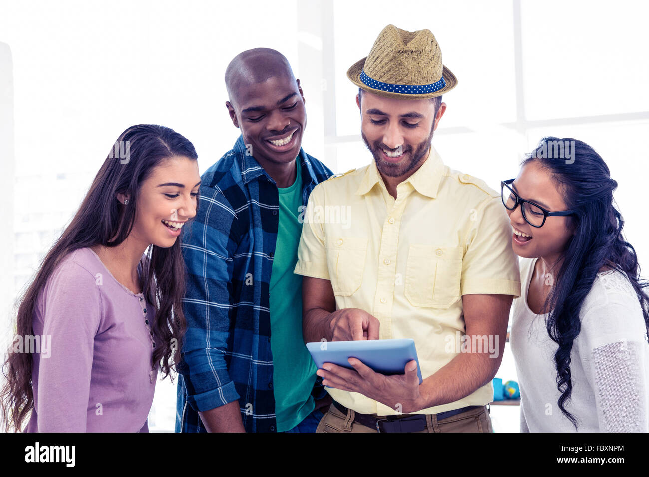 Cheerful creative team using tablet PC Stock Photo - Alamy