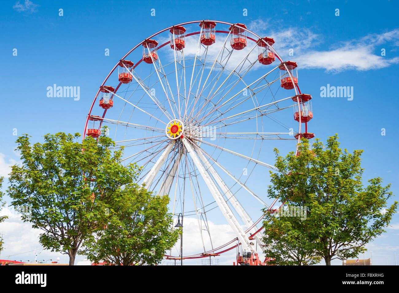 Red Ferris Wheel against blue sky at amusement park Stock Photo - Alamy