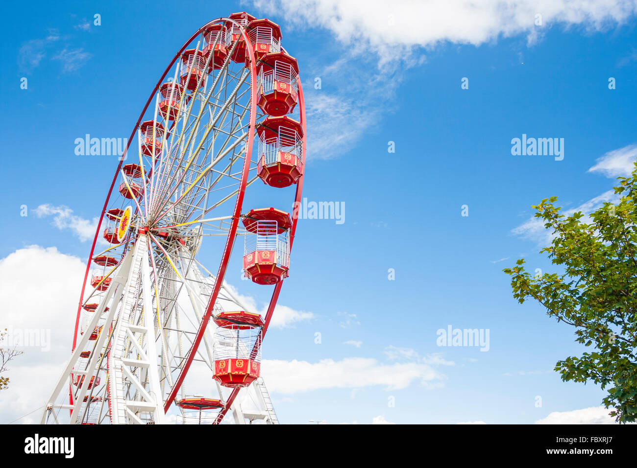 Red Ferris Wheel against blue sky at amusement park Stock Photo - Alamy