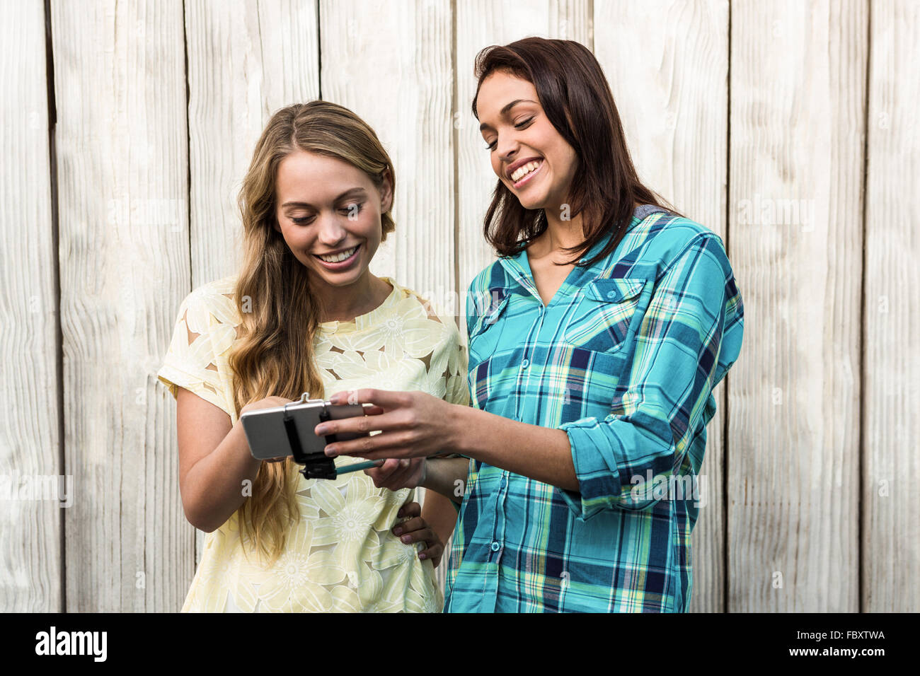 Two friends looking at mobile phone Stock Photo - Alamy