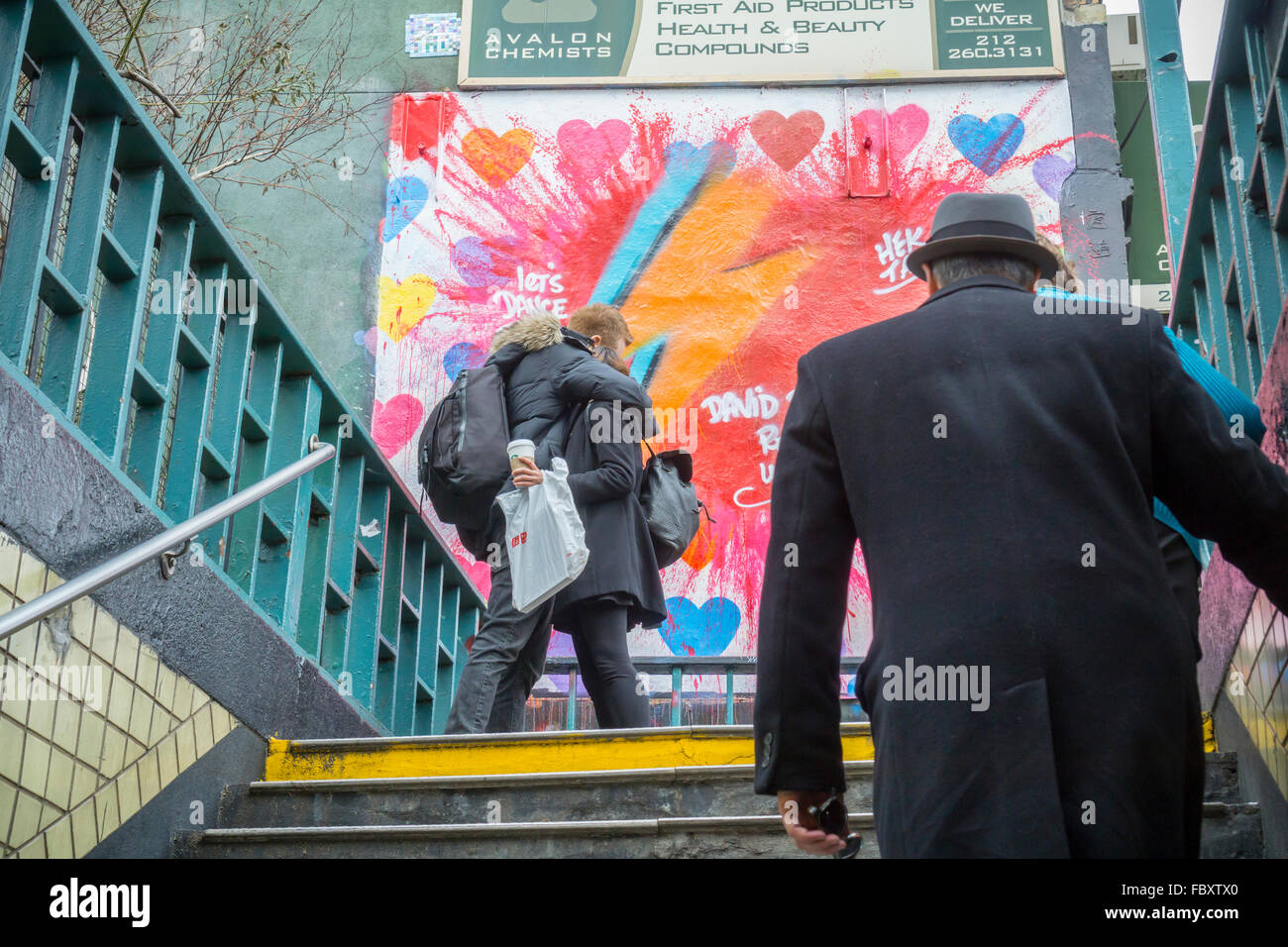 A couple embraces in front of a mural by the artist Hektad in the East ...