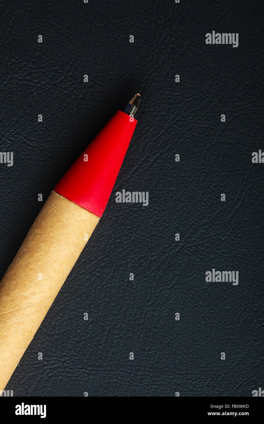 Red pen writing material on black leather background Stock Photo - Alamy