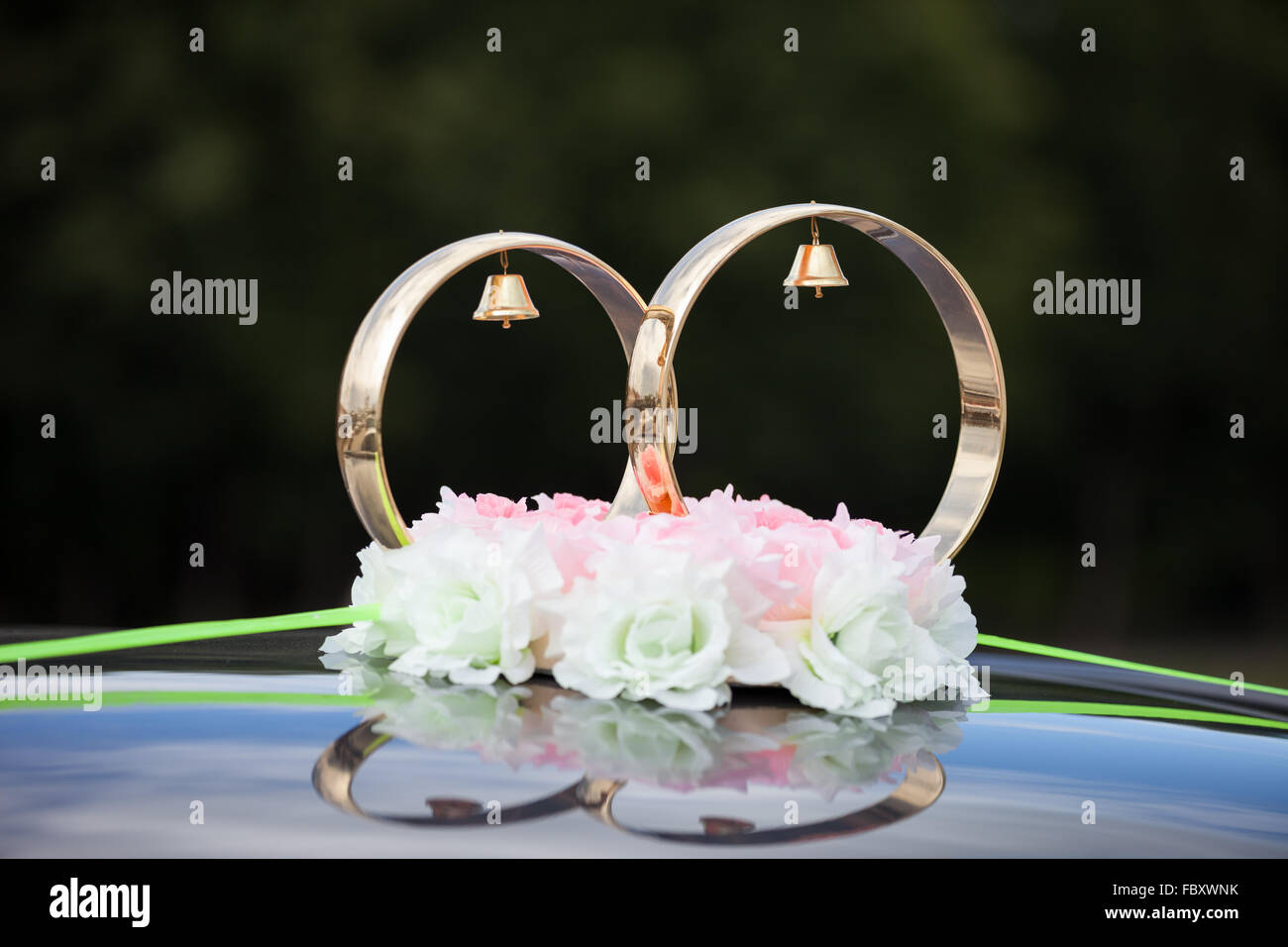 Gold rings and rose flowers on wedding car Stock Photo - Alamy