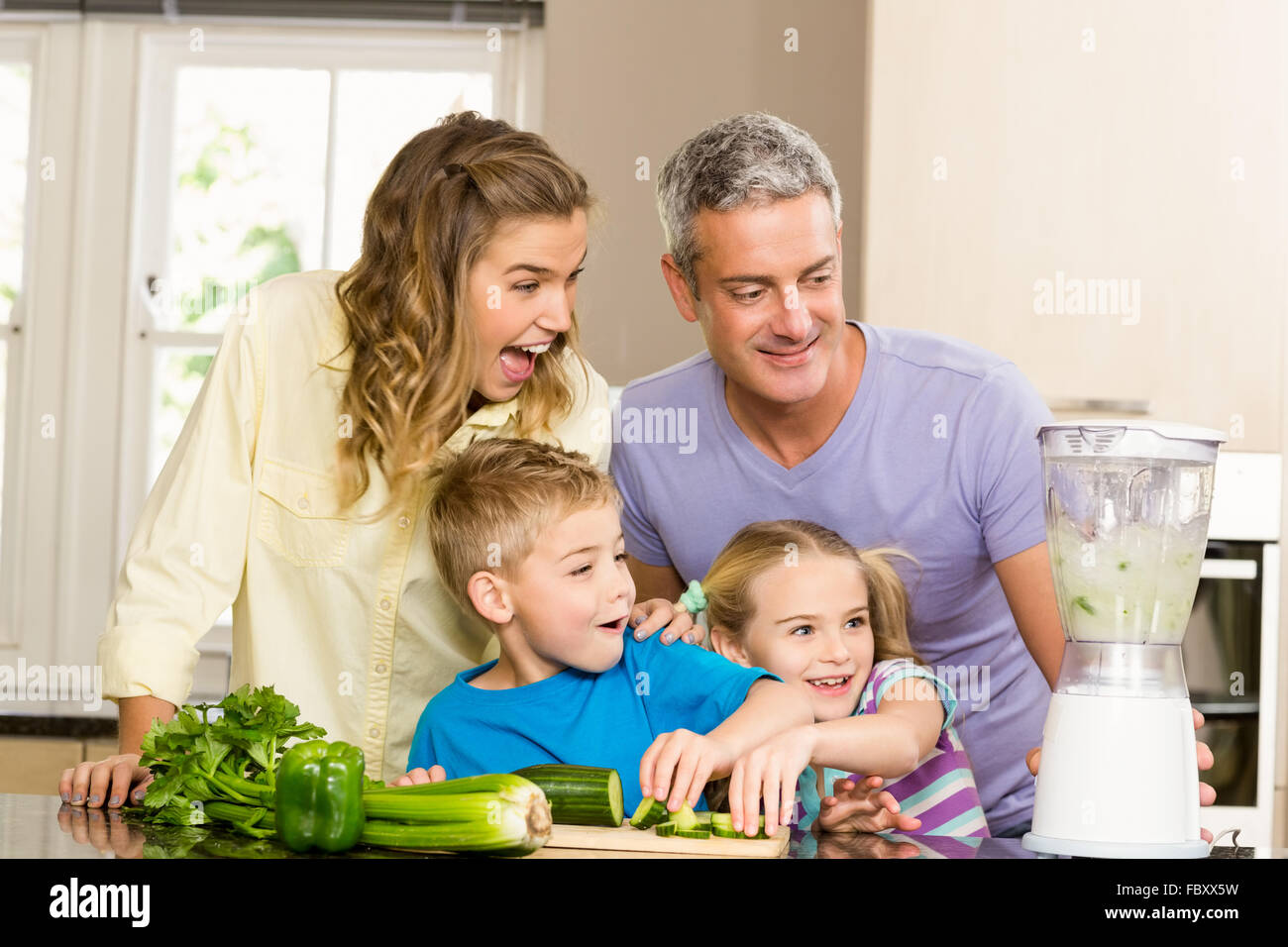 Happy family preparing healthy smoothie Stock Photo - Alamy