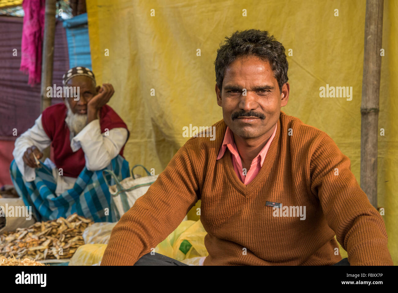 Indian market. Two seated male market traders selling assorted dried ...
