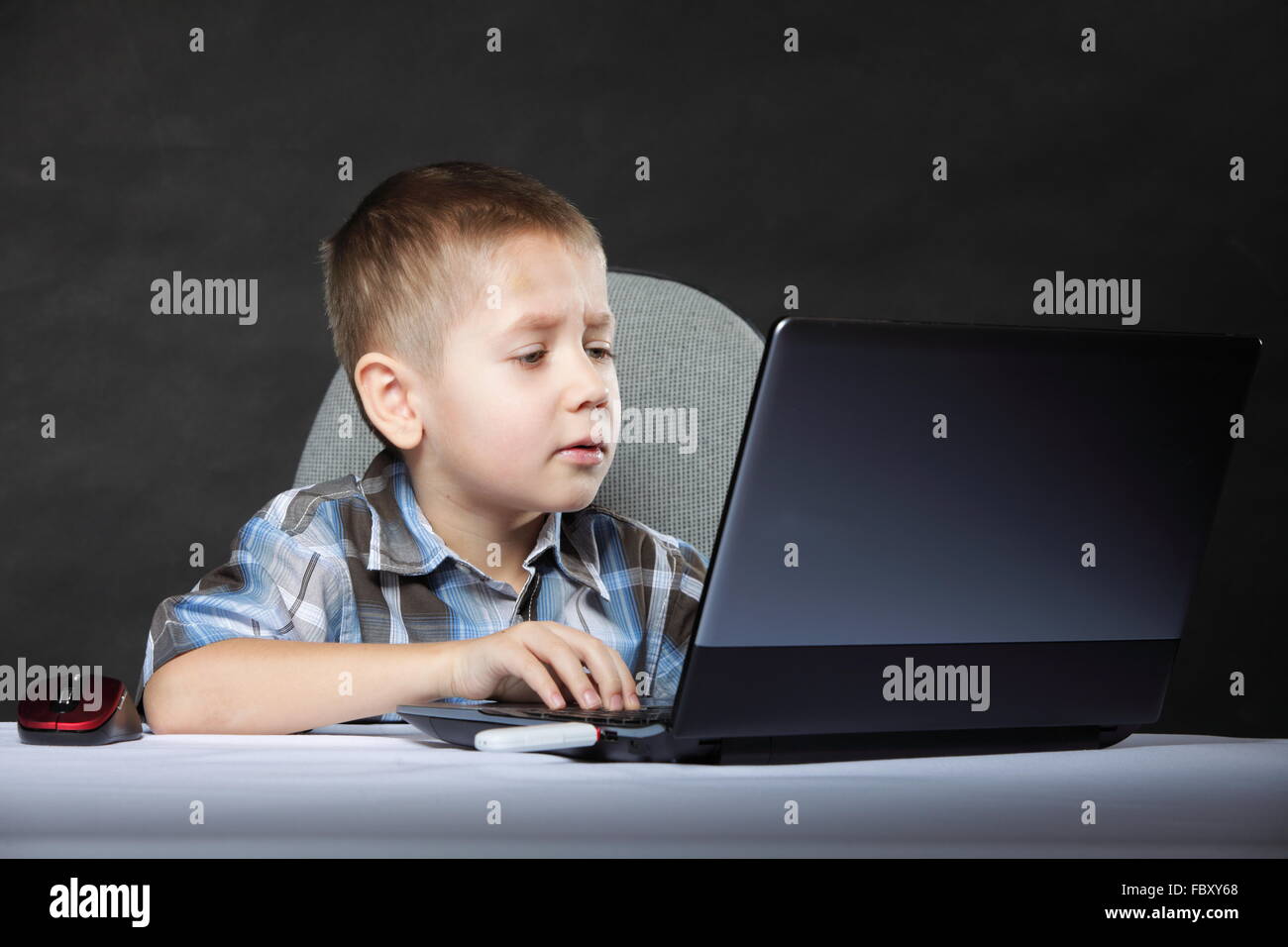 Computer addiction child with laptop notebook Stock Photo - Alamy