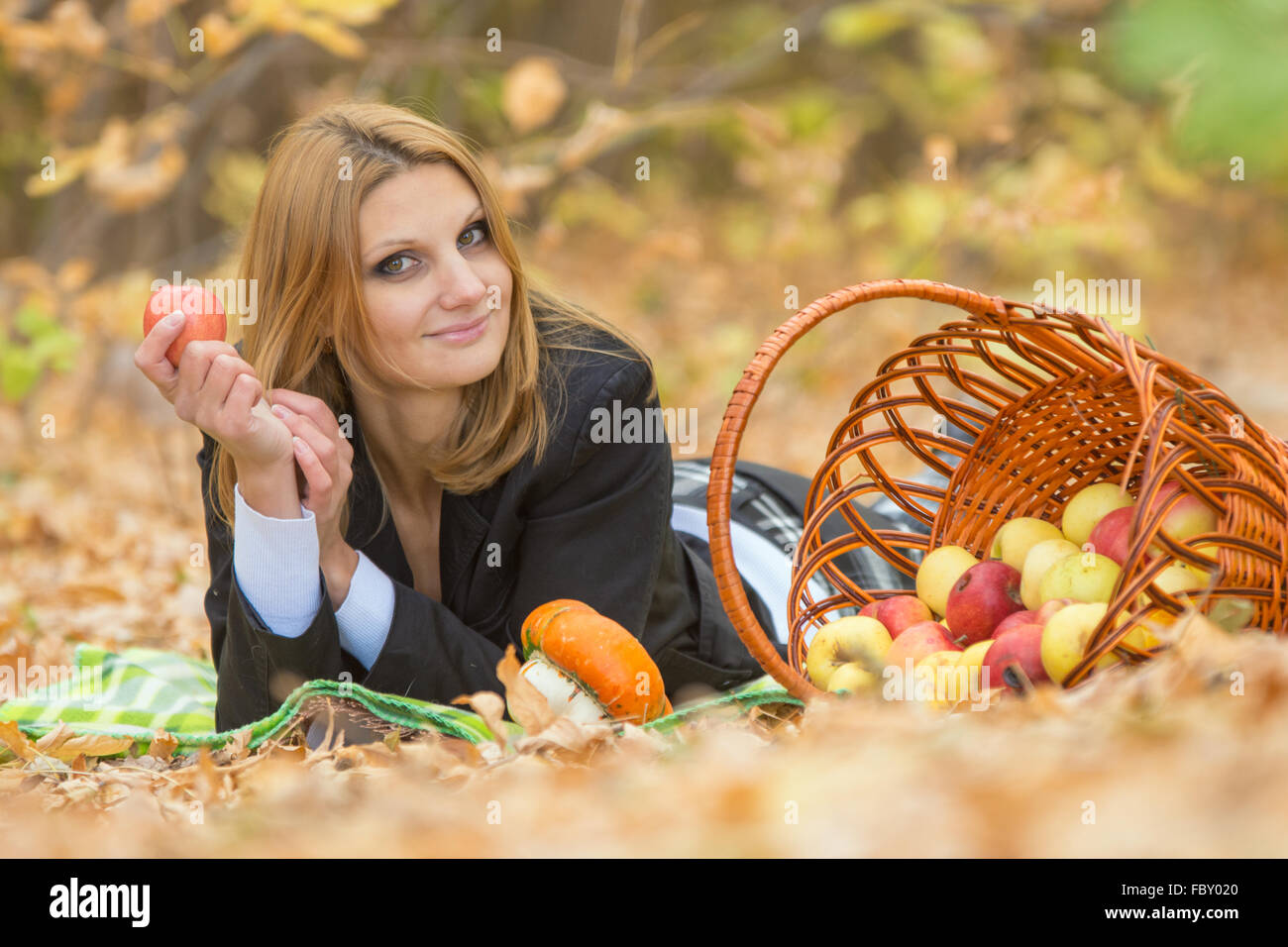 Young beautiful girl lying on the leaves in the autumn forest, lies ...