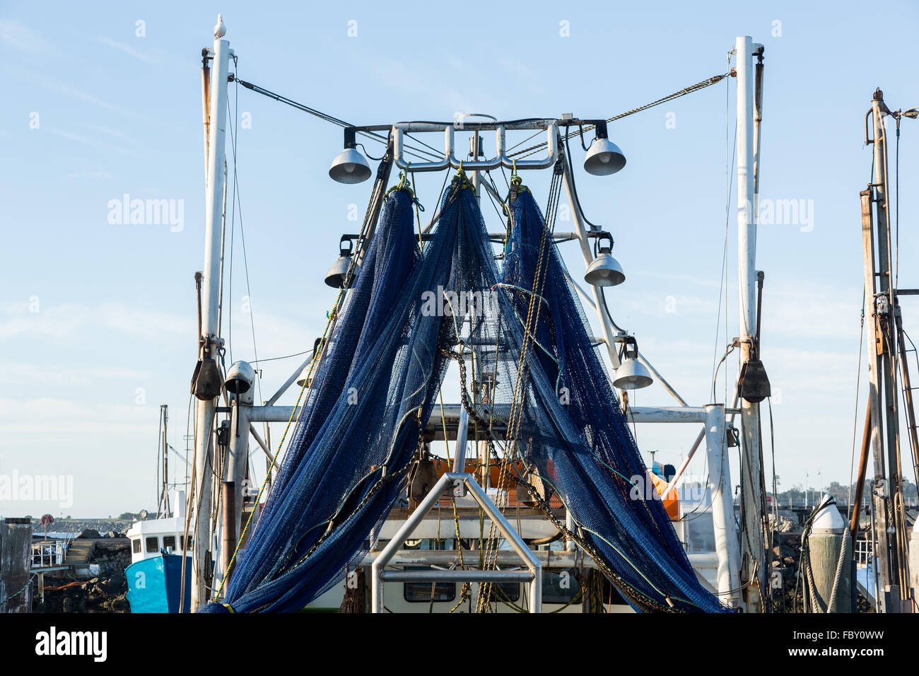 Blue fishing nets or trawl hanging from ship Stock Photo - Alamy